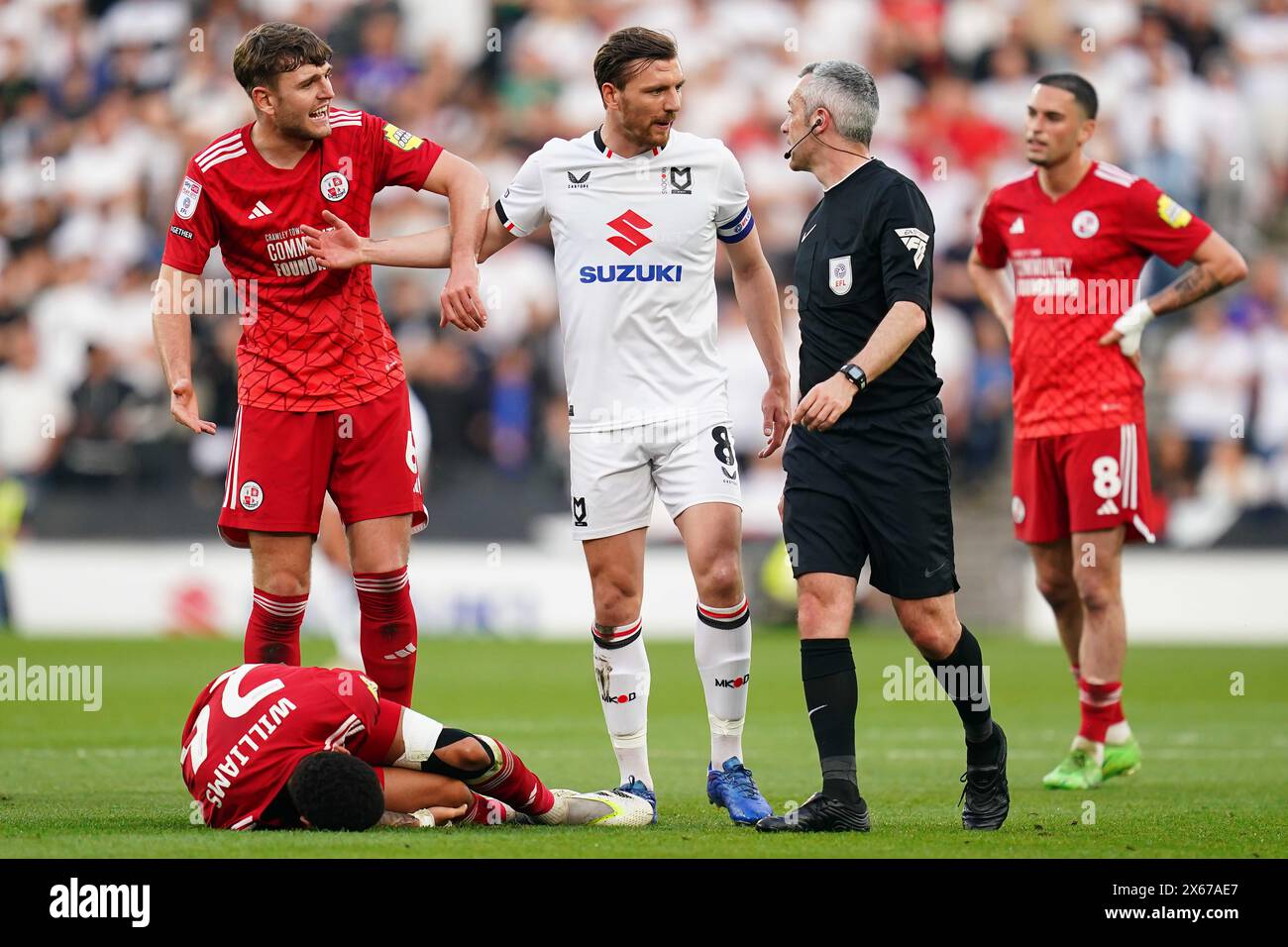 Crawley Town's Laurence Maguire and MK Dons' Alex Gilbey exchange words ...