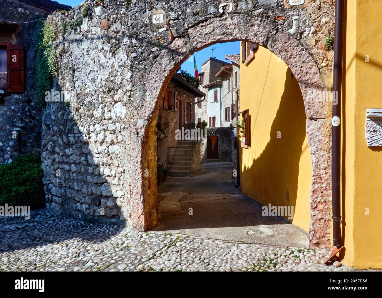 Historic brick arch gateway in the narrow alley of the small Italian ...