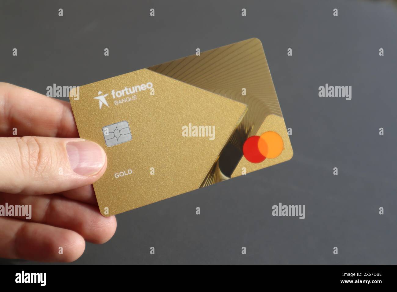 Nice, France - 11.05.2024: Man's hand holding a Mastercard bank card ...