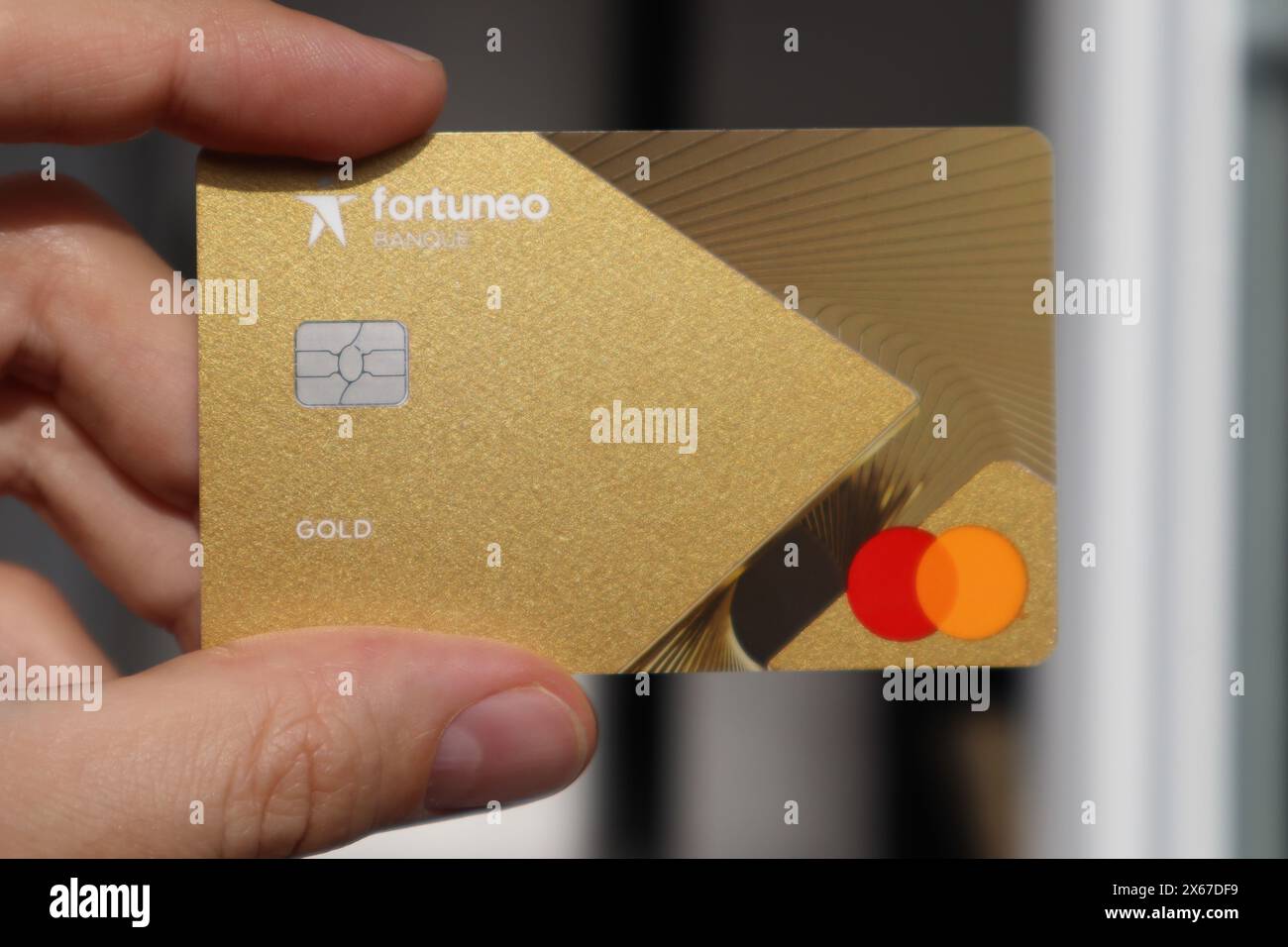 Nice, France - 11.05.2024: Man's hand holding a Mastercard bank card ...