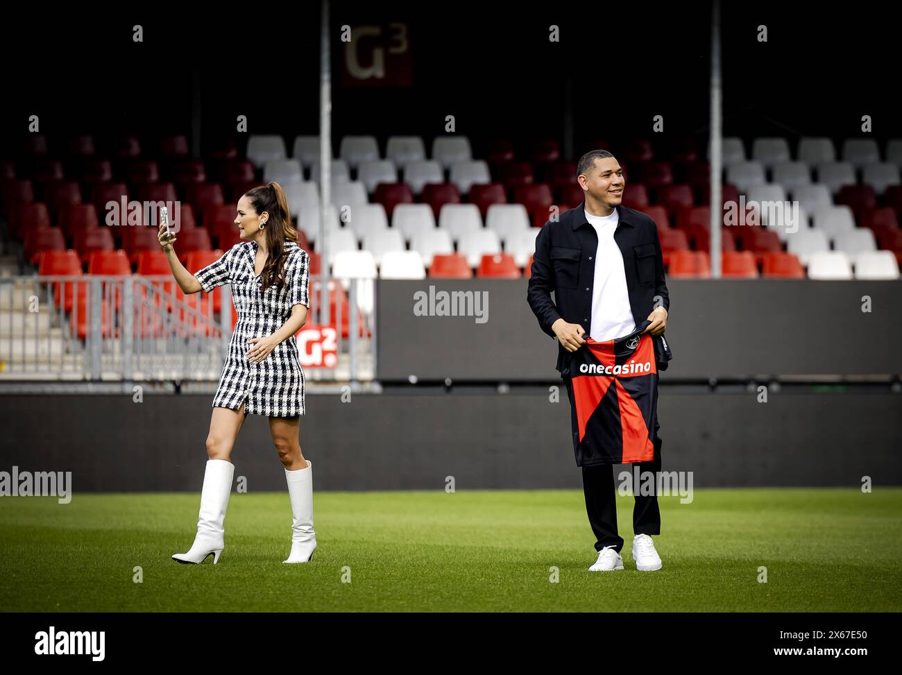 ALMERE - Hedwiges Maduro walks across the field with his girlfriend ...