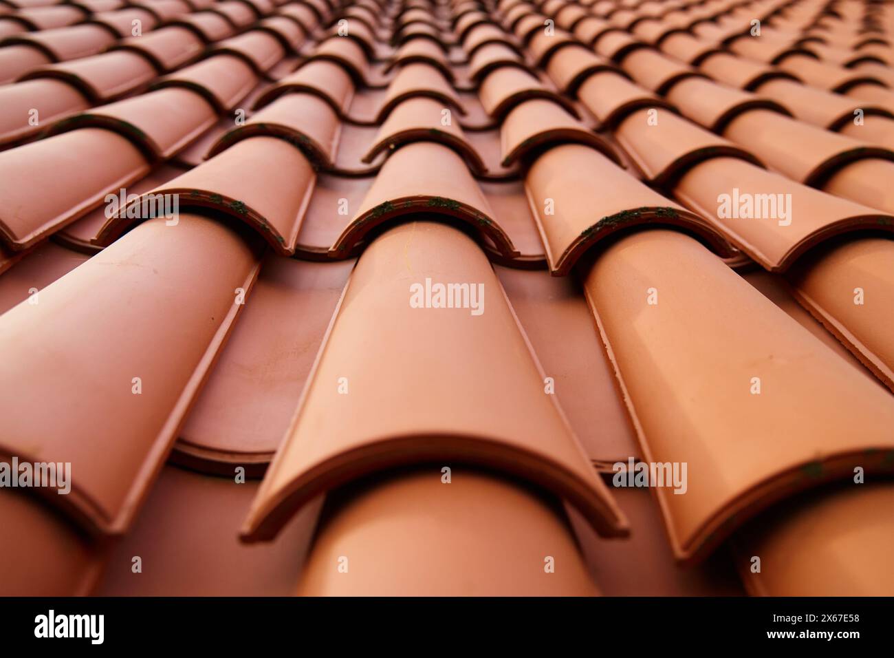 Red ceramic roof tiles covering residential building roof. Tile pattern ...