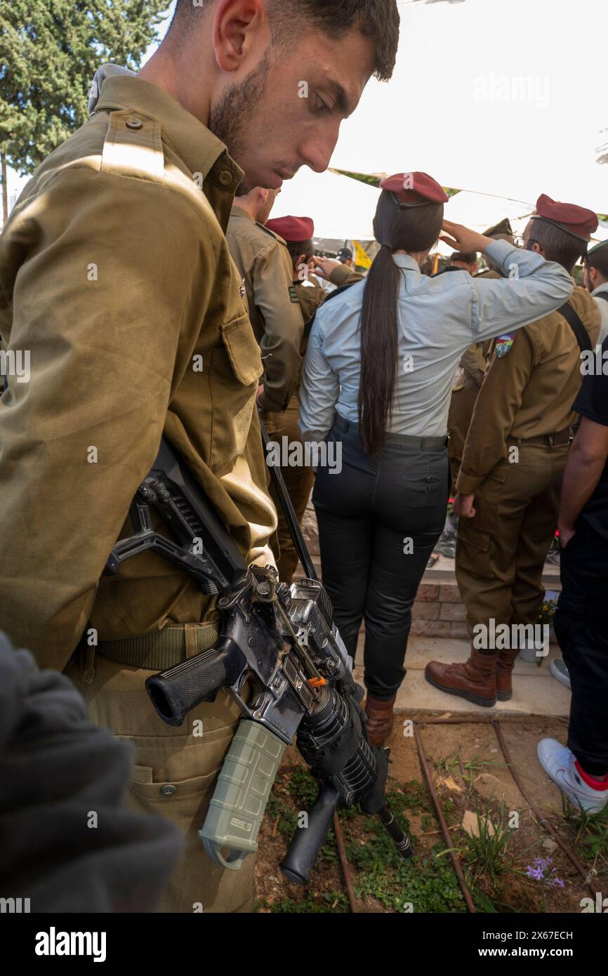 Ashkelon, Israel. 13th May, 2024. An Israeli soldier bows his head as a ...
