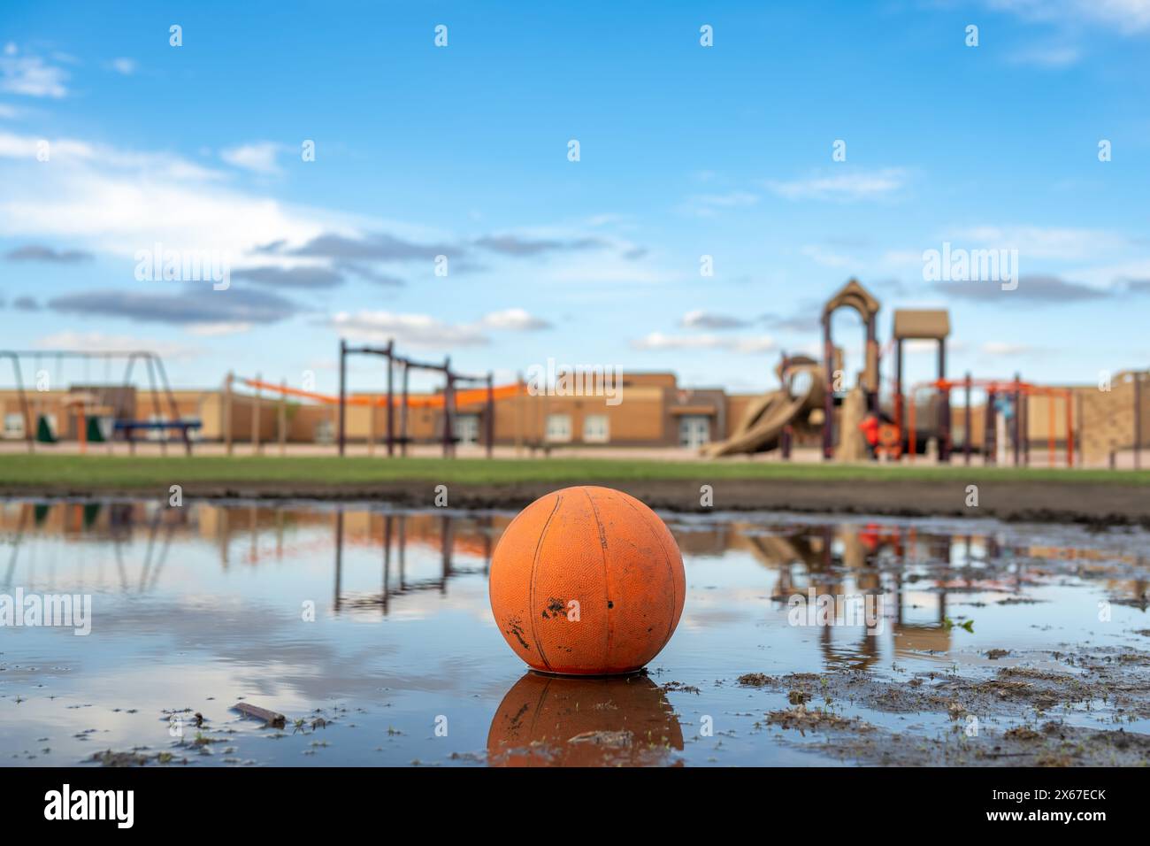 Selective focus on mud in front of a basketball sitting in a mudpuddle ...