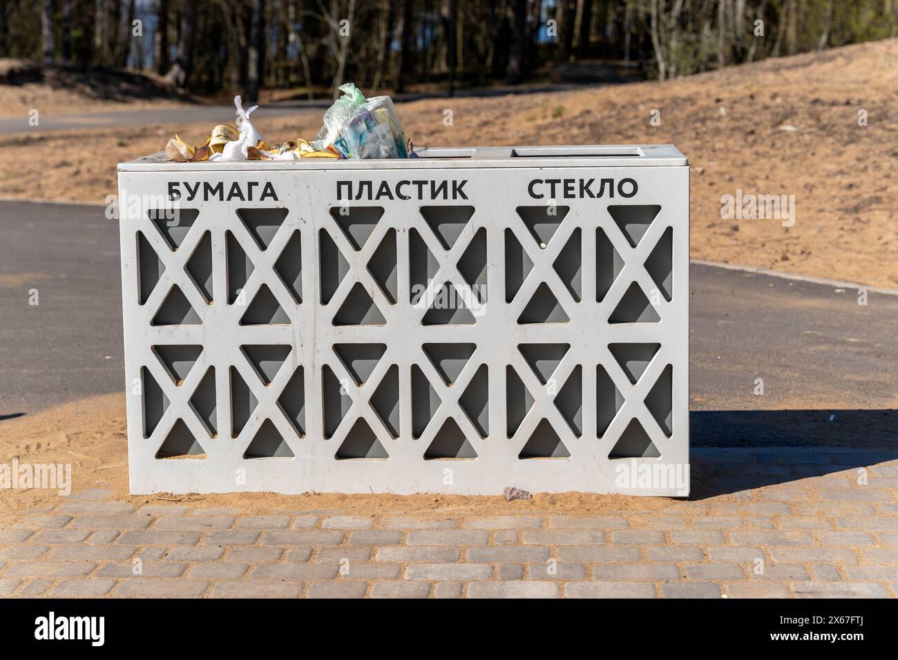 A trash can placed on the side of a road for waste disposal Stock Photo ...
