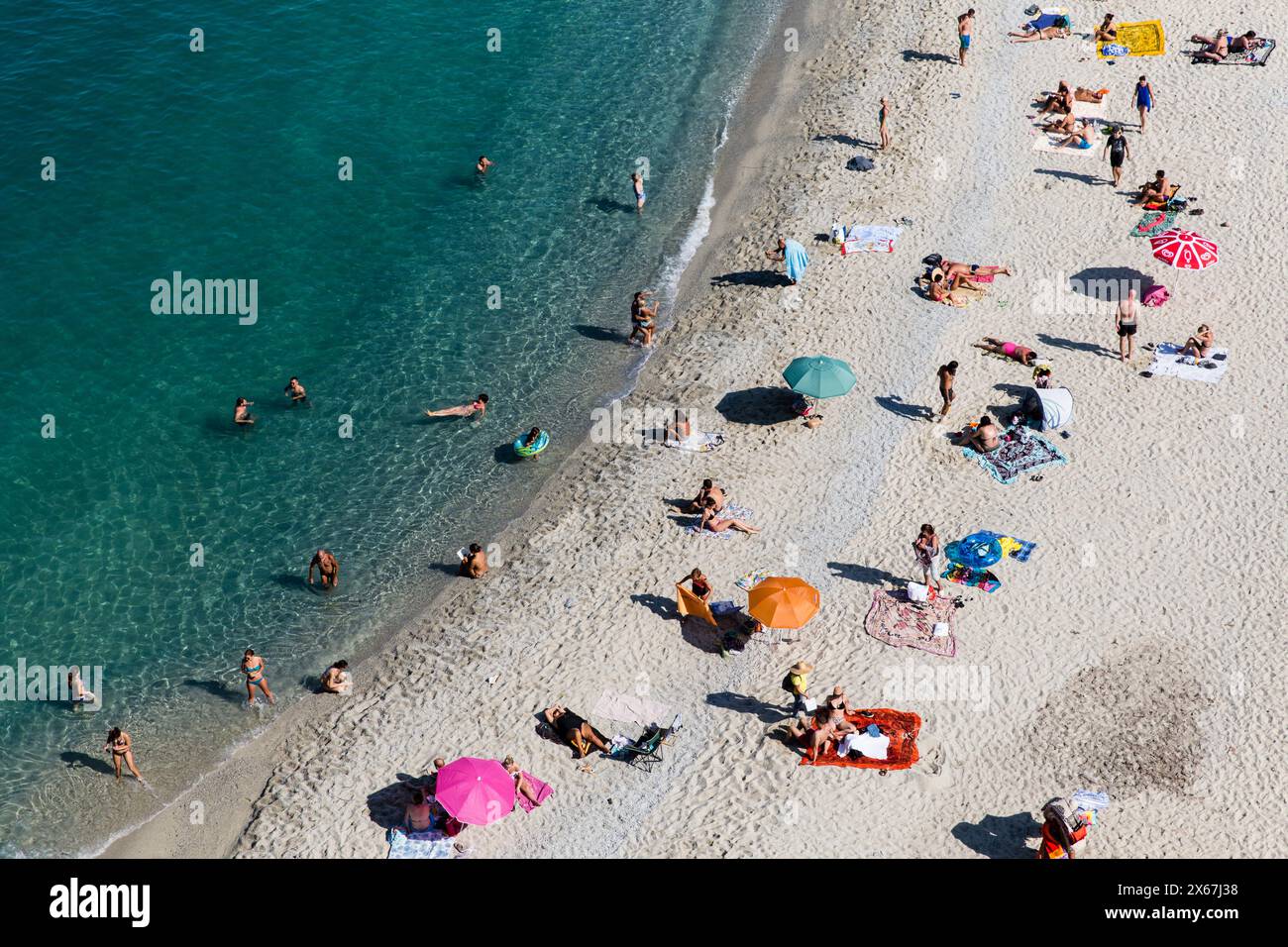 Visitors bathing and sunbathing on the beach at Tropea, taken from ...