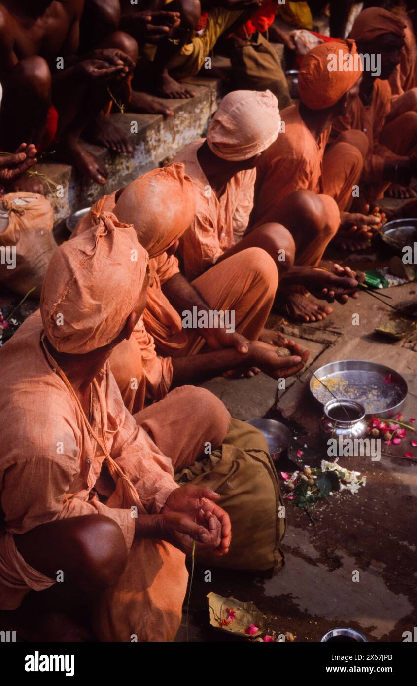 Group of traditional worshipers engaged in sacred rituals by a river ...