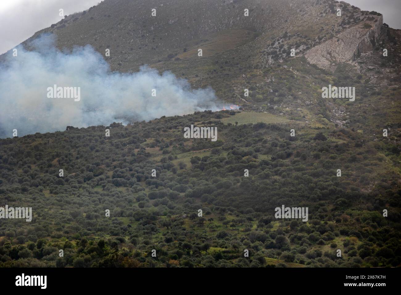 smoke from a fire on a mountain side in Sicily, April 2024 Stock Photo ...