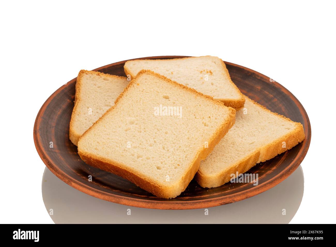 Several pieces of white toaster bread on a clay plate, macro, isolated ...