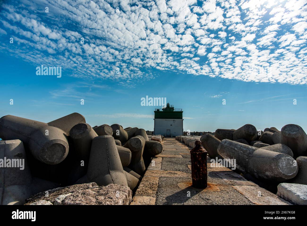 green lighthouse of Malamocco harbor inlet with concrete breakwaters ...