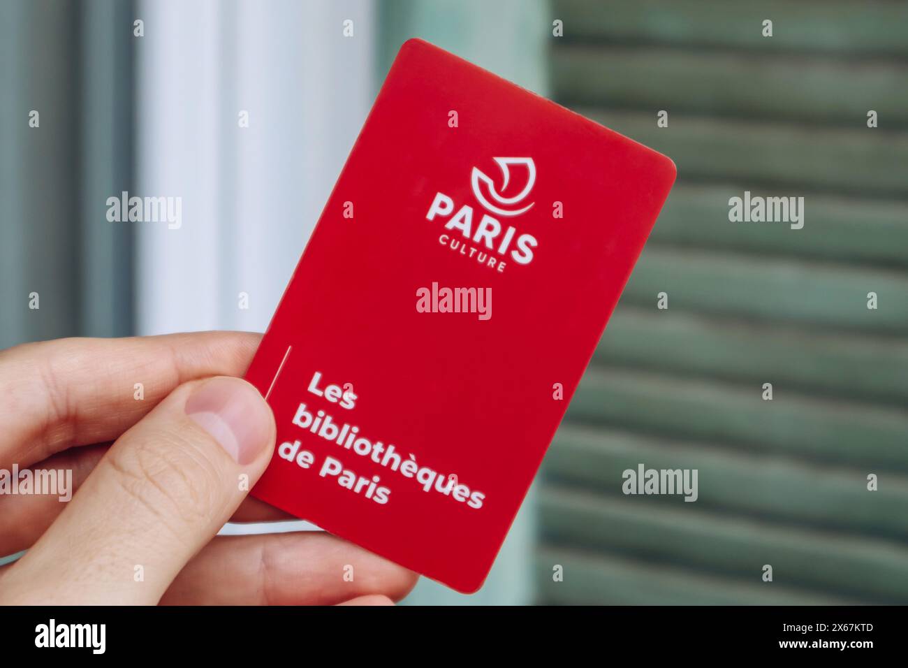Nice, France - 27.01.2024: A man's hand holds a card of Paris libraries ...