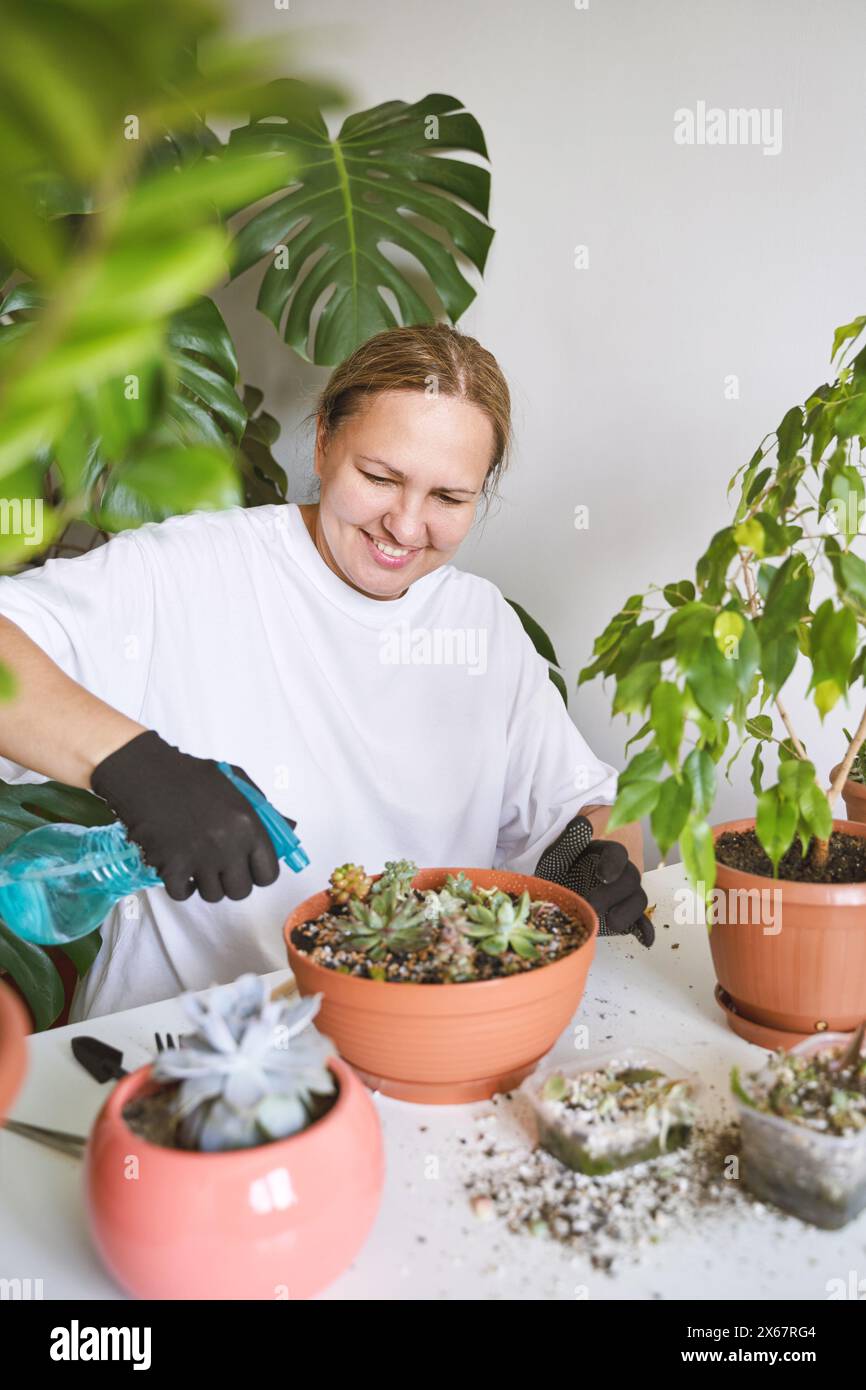 In a cozy room, a smiling woman tends to her beloved plants with care ...