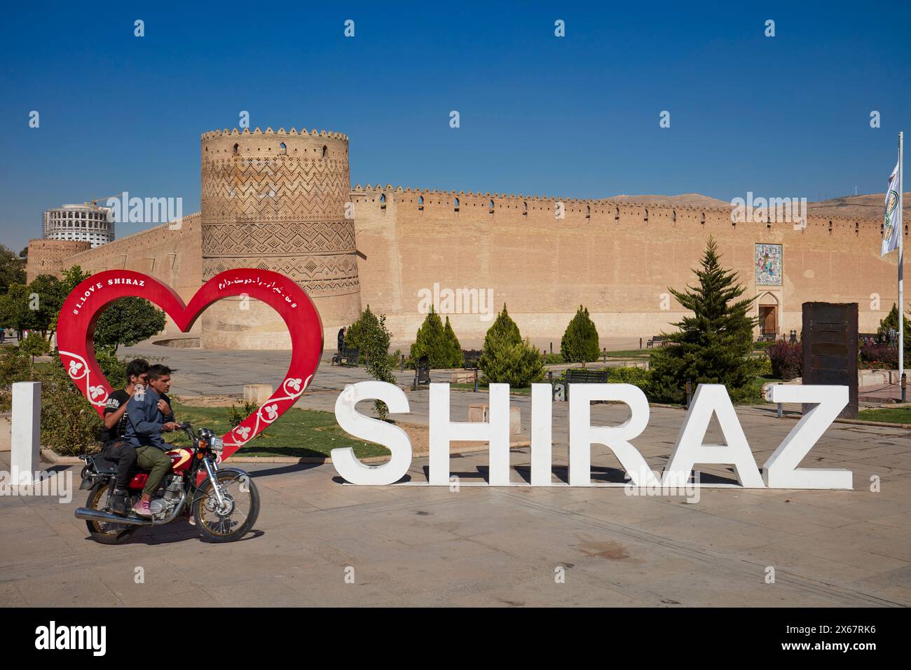 Two Iranian men ride together on a motorbike at the Arg of Karim Khan ...