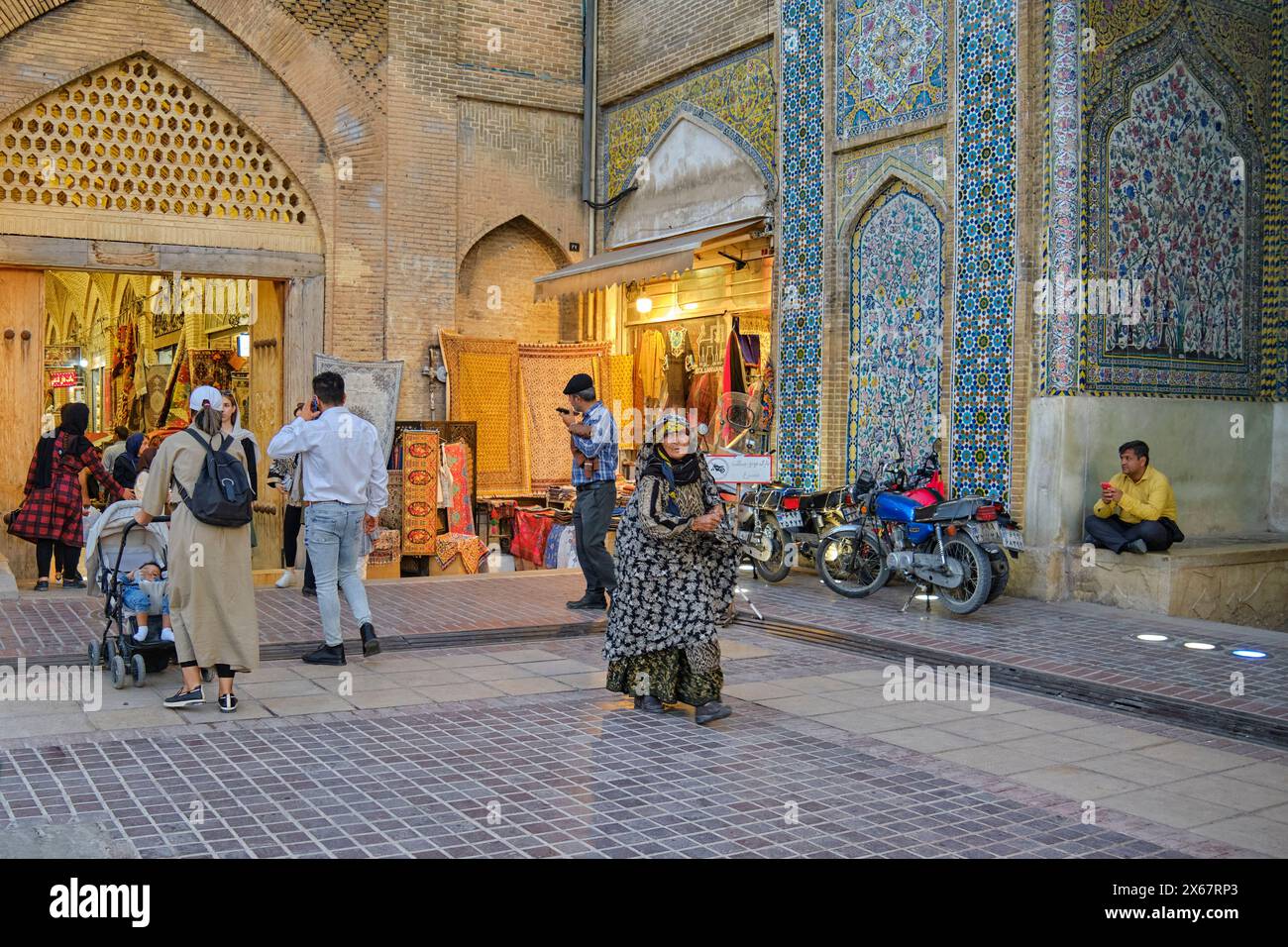 Senior Iranian woman wearing traditional clothing walks at the entrance ...