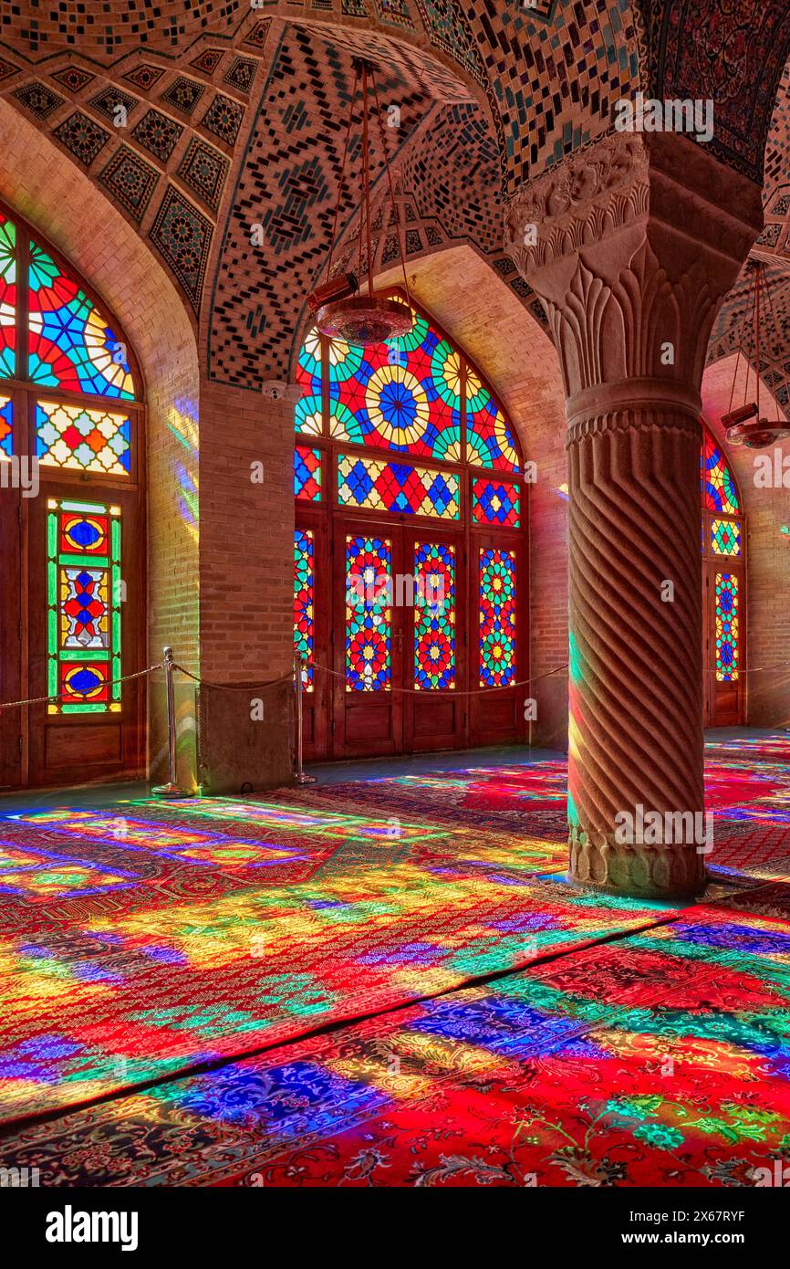 A play of light from multi-colored stained-glass windows on carpeted ...