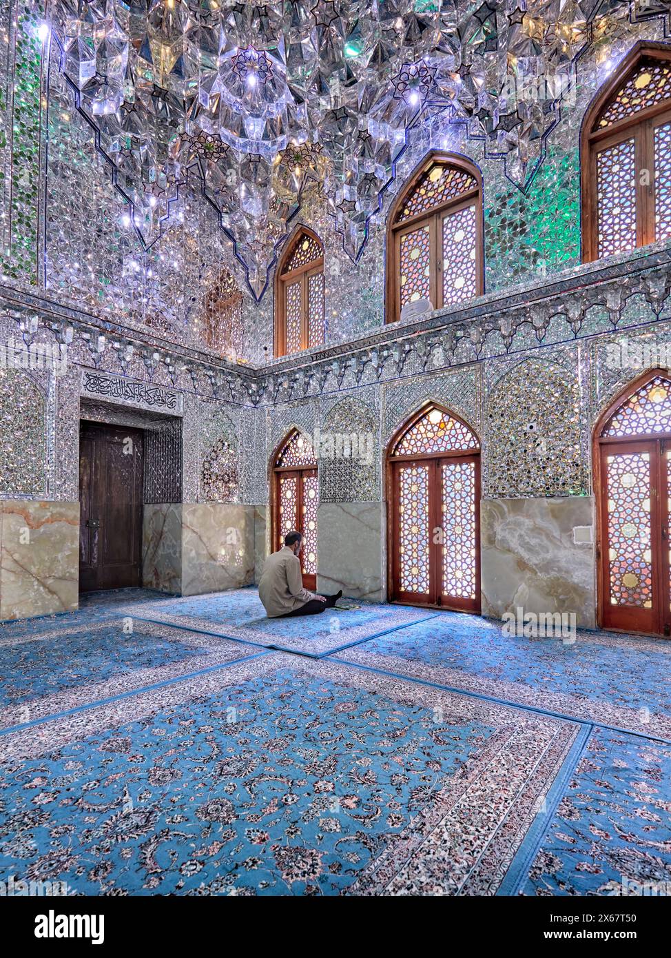 A man prays in the Ali Ibn Hamzeh Holy Shrine elaborately decorated ...