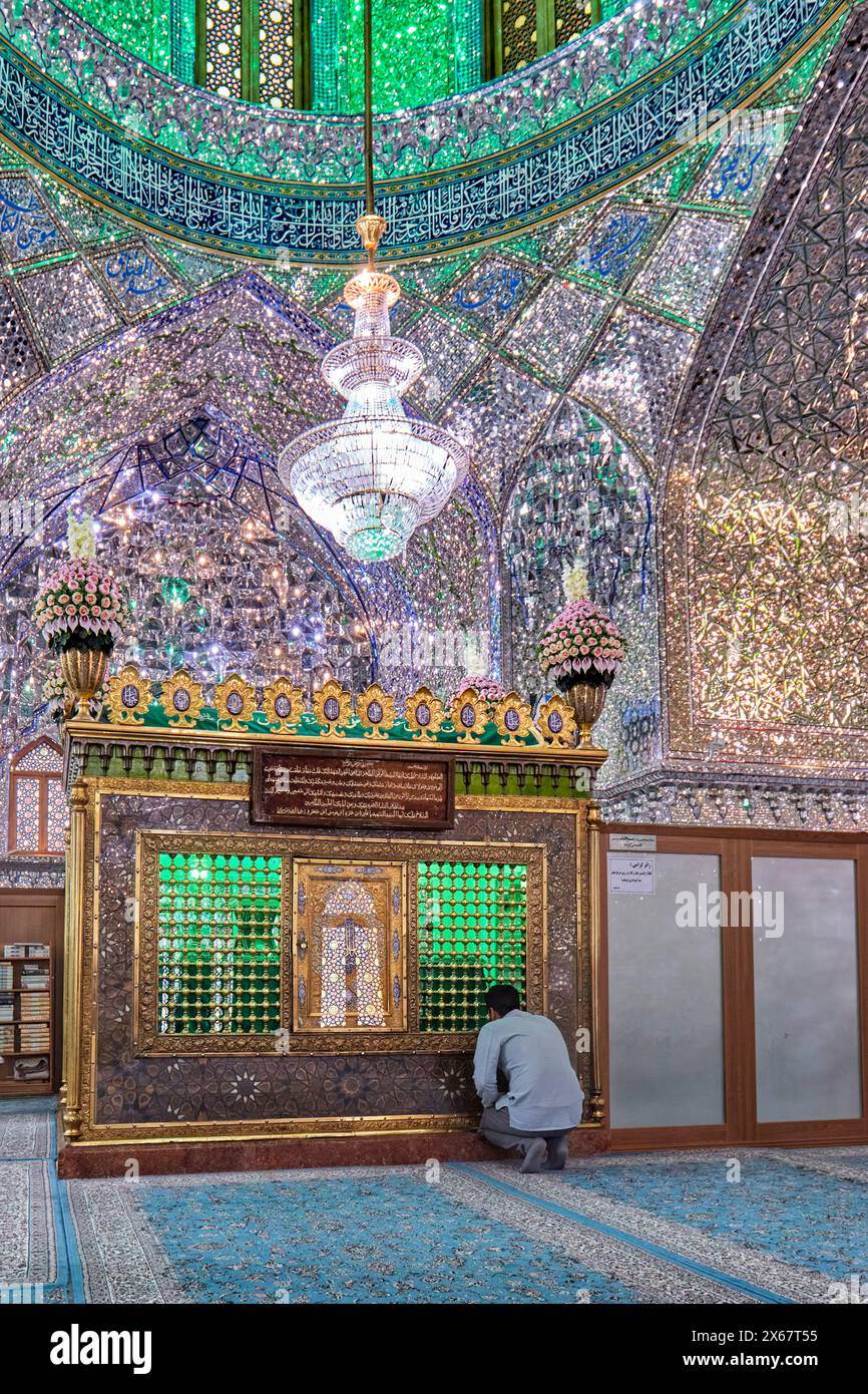 A man prays in the Ali Ibn Hamzeh Holy Shrine elaborately decorated ...