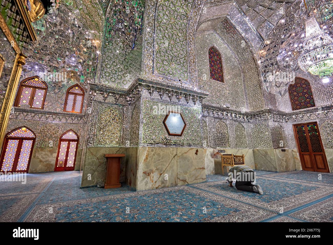 A man prays in the Ali Ibn Hamzeh Holy Shrine elaborately decorated ...
