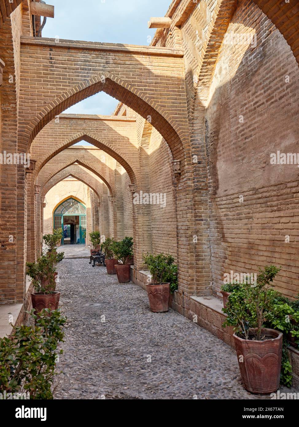 View down a narrow street with arches above in the historic center of ...