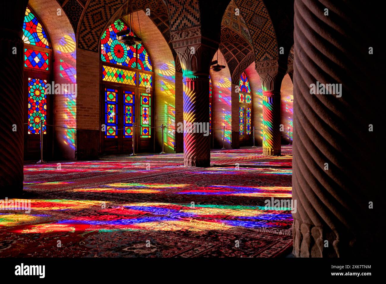 A play of light from multi-colored stained-glass windows inside the ...
