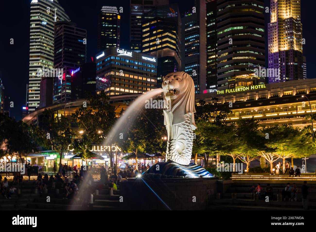 Crowds of people around the Merlion statue in the Marina Bay area of ...