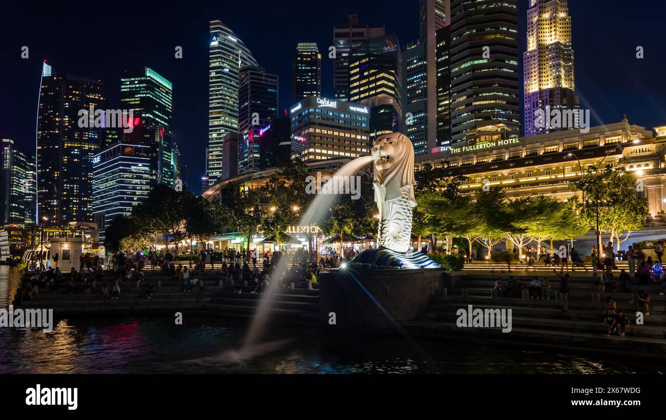 Crowds of people around the Merlion statue in the Marina Bay area of ...