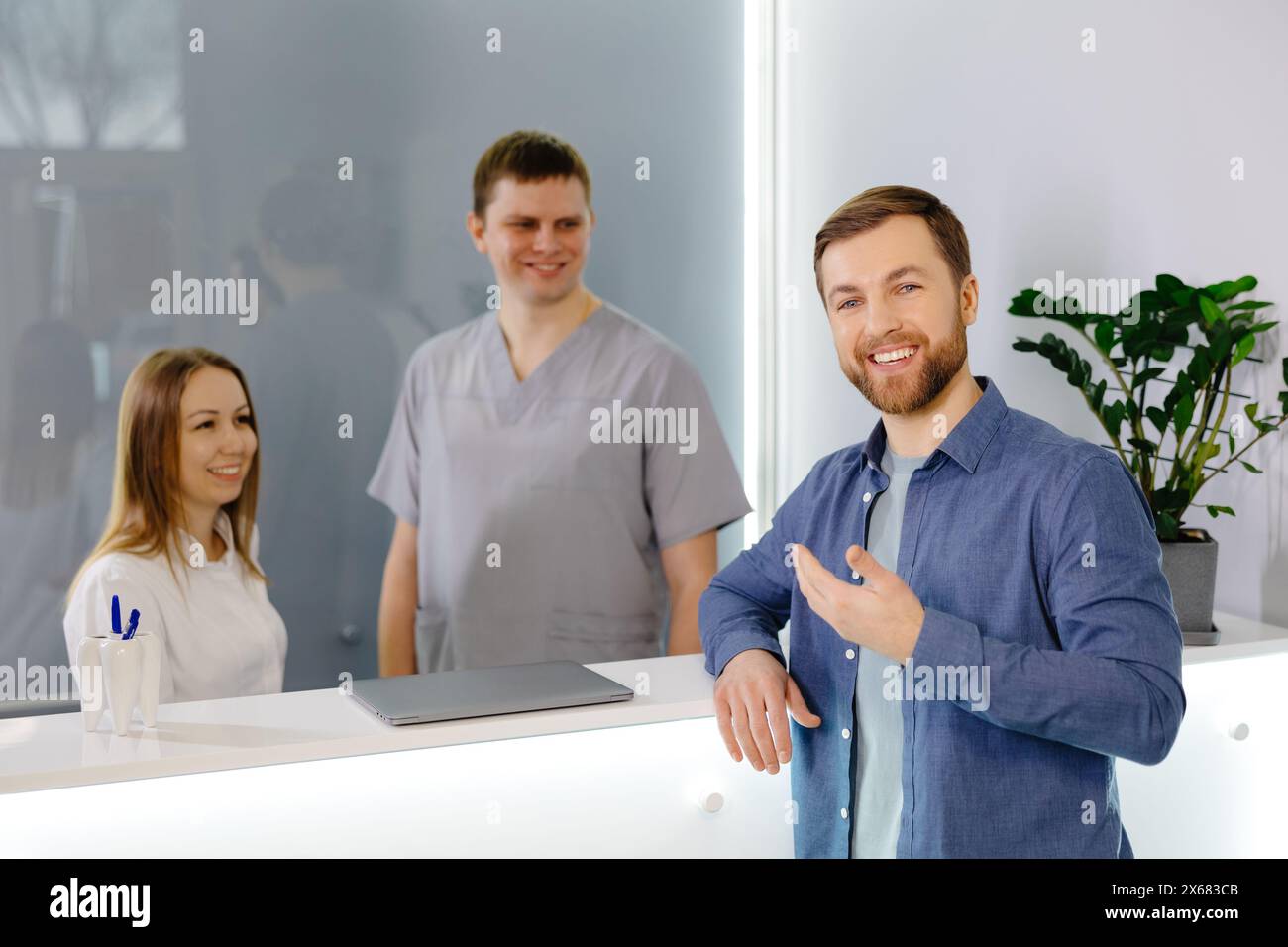 Grateful patient. Man standing at the reception of dental clinic and ...