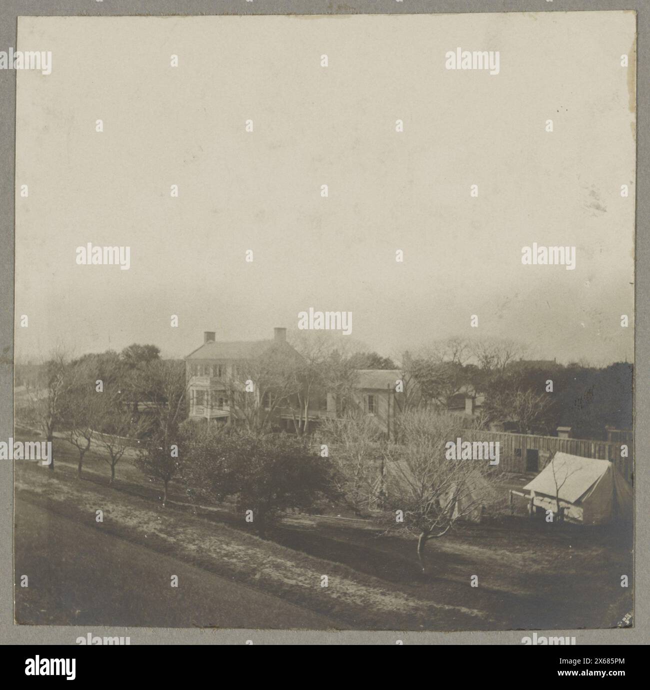 An aerial view of a house, tents, and other buildings partly obscured ...