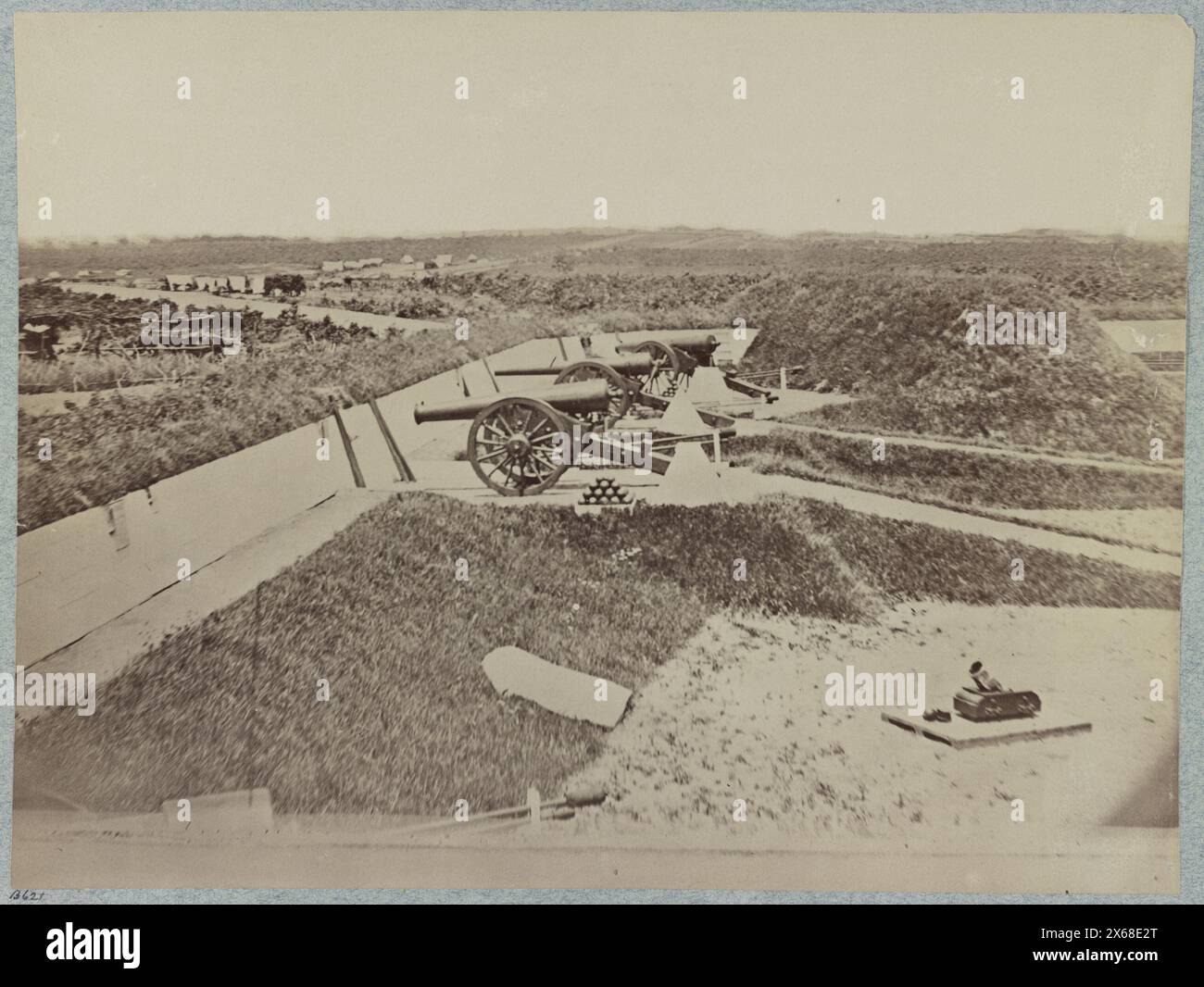 Mounted guns and ammunition around the perimeter of a fort, and tents ...