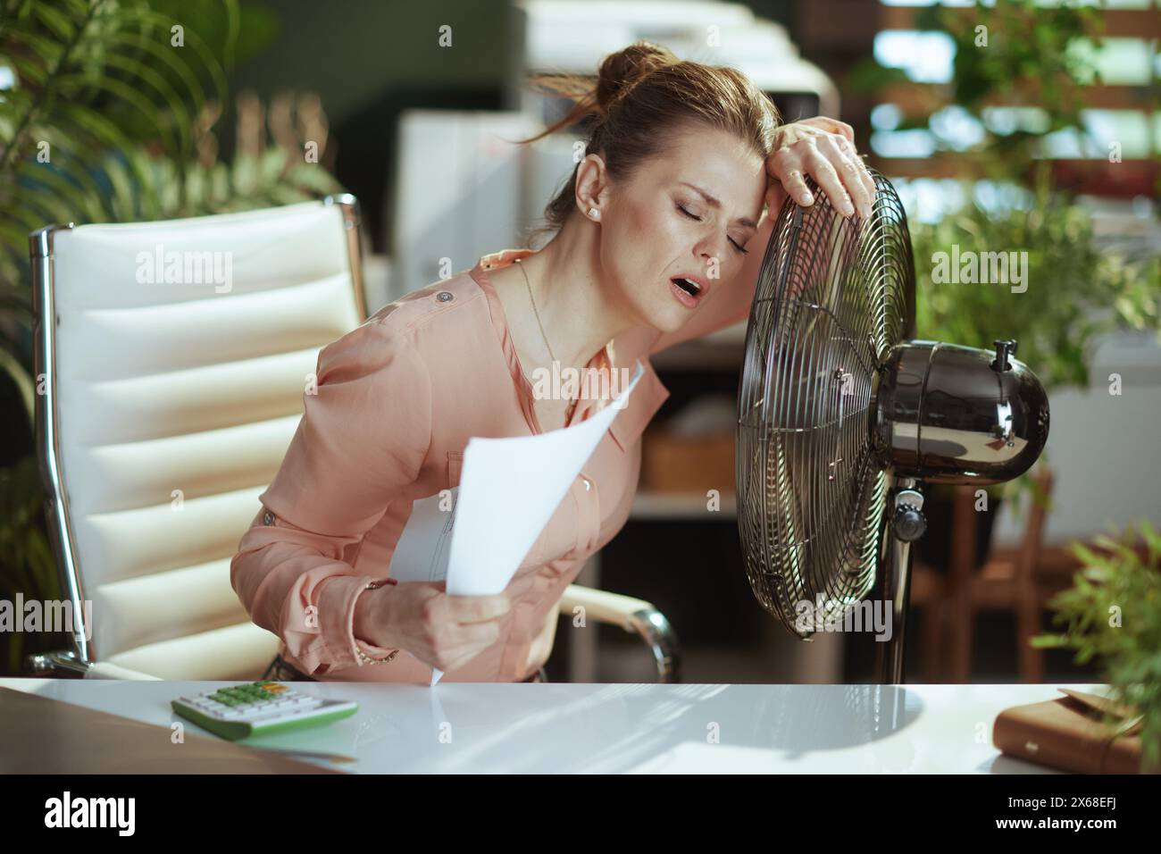 Sustainable workplace. modern female employee at work with documents ...