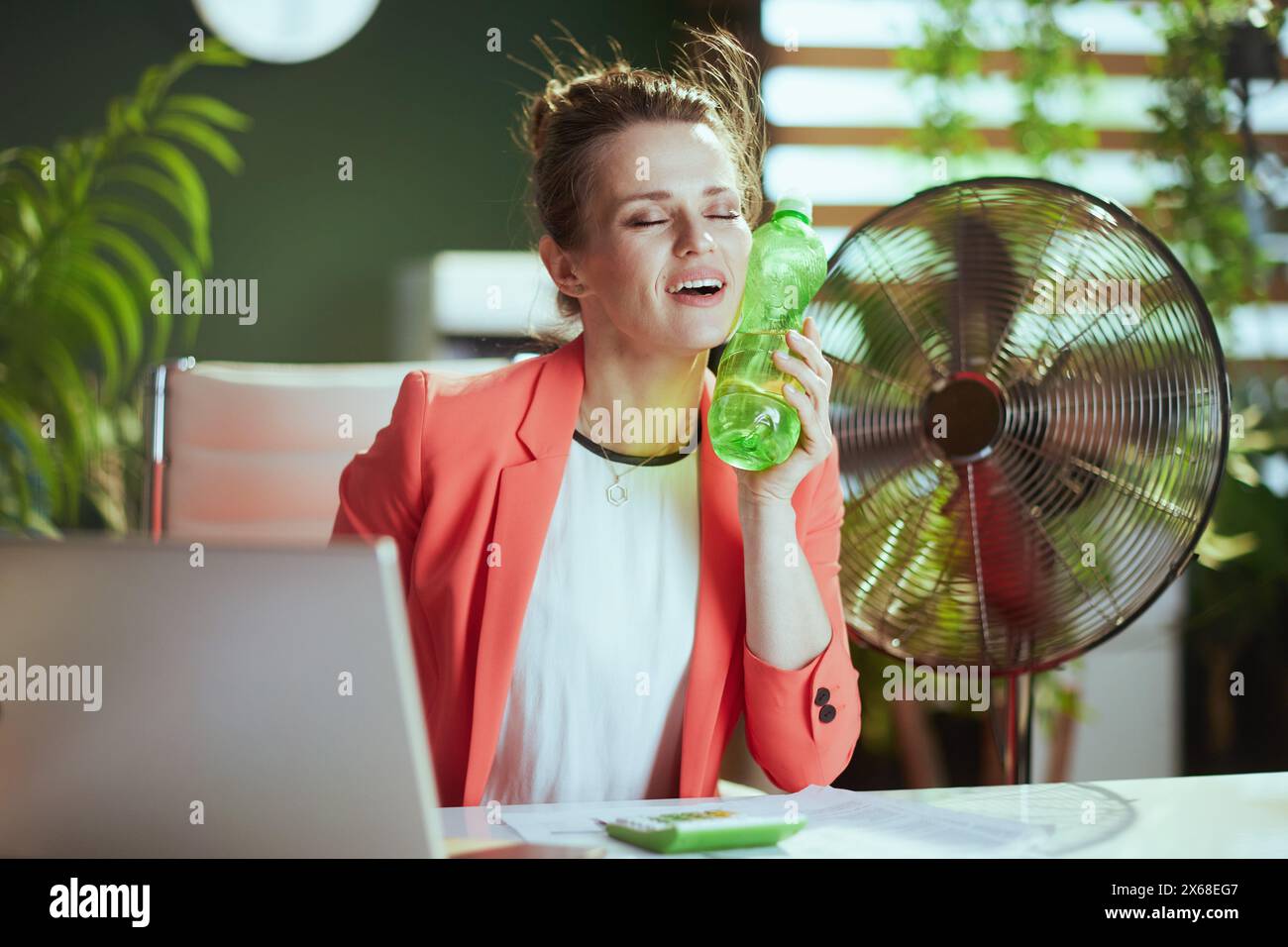 Sustainable workplace. smiling modern female worker at work in red ...