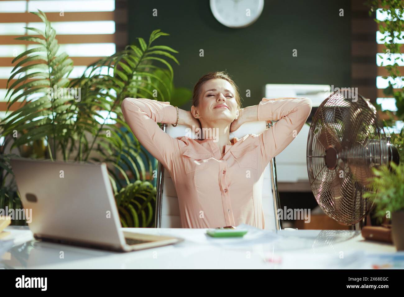 Sustainable workplace. relaxed modern female employee in modern green ...