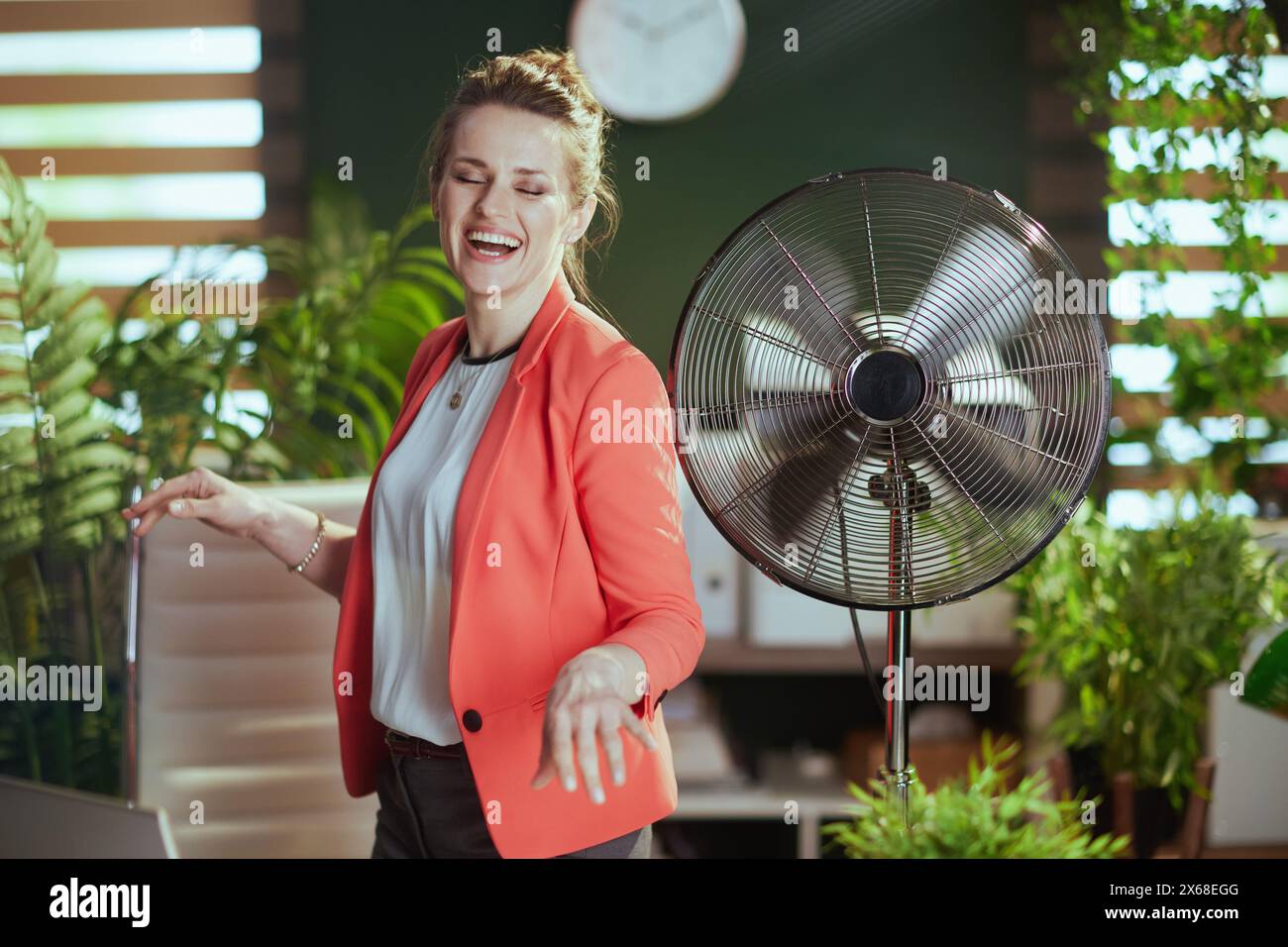 Sustainable workplace. happy modern woman worker in modern green office ...