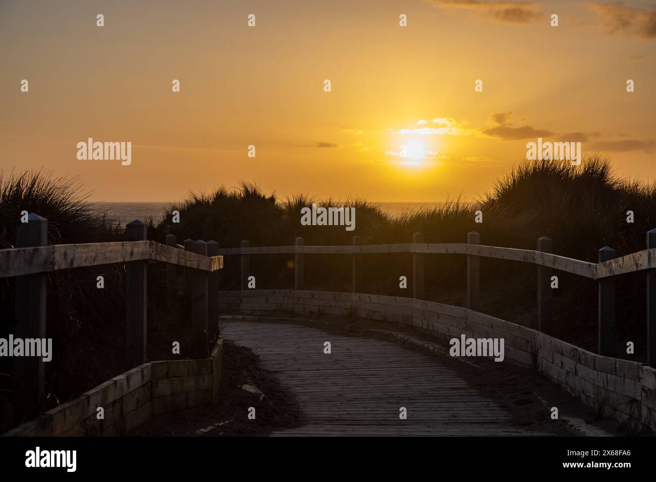 A pathway to the sea with a sunset sky overhead Stock Photo - Alamy