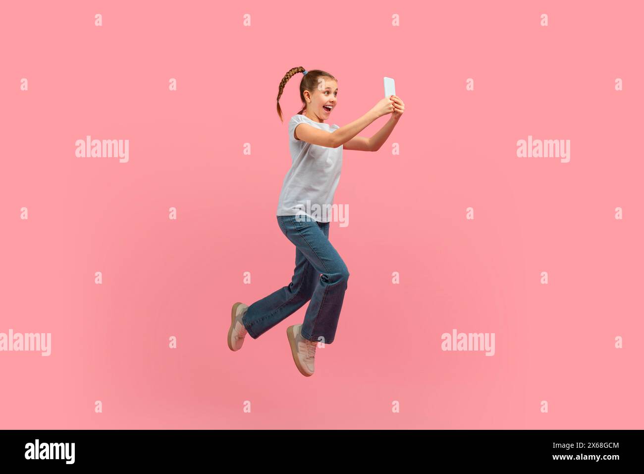 Girl Jumping in the Air With Cell Phone Stock Photo - Alamy