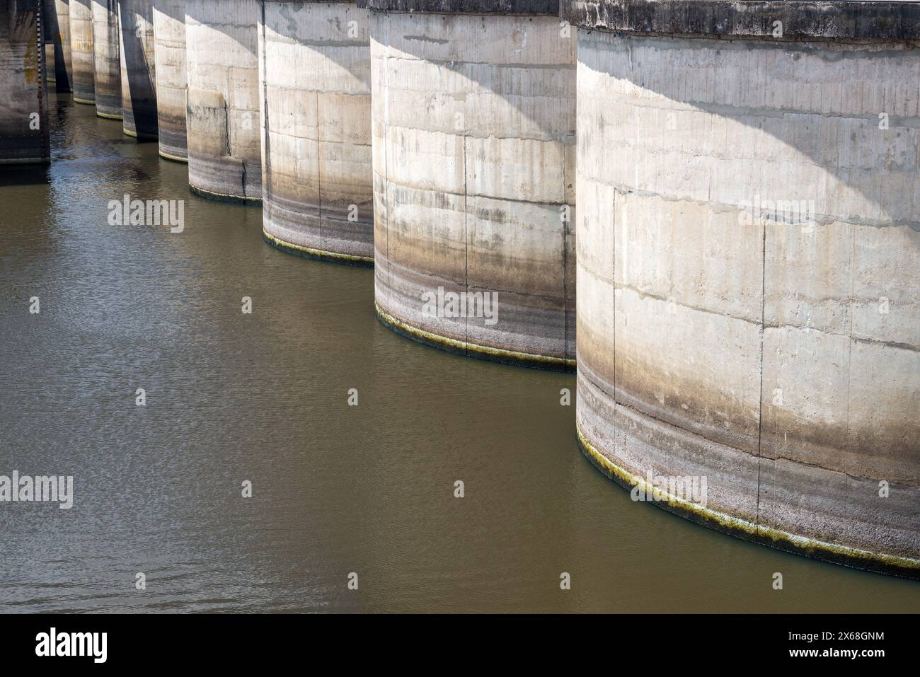 The water is calm and the river is surrounded by concrete walls Stock ...