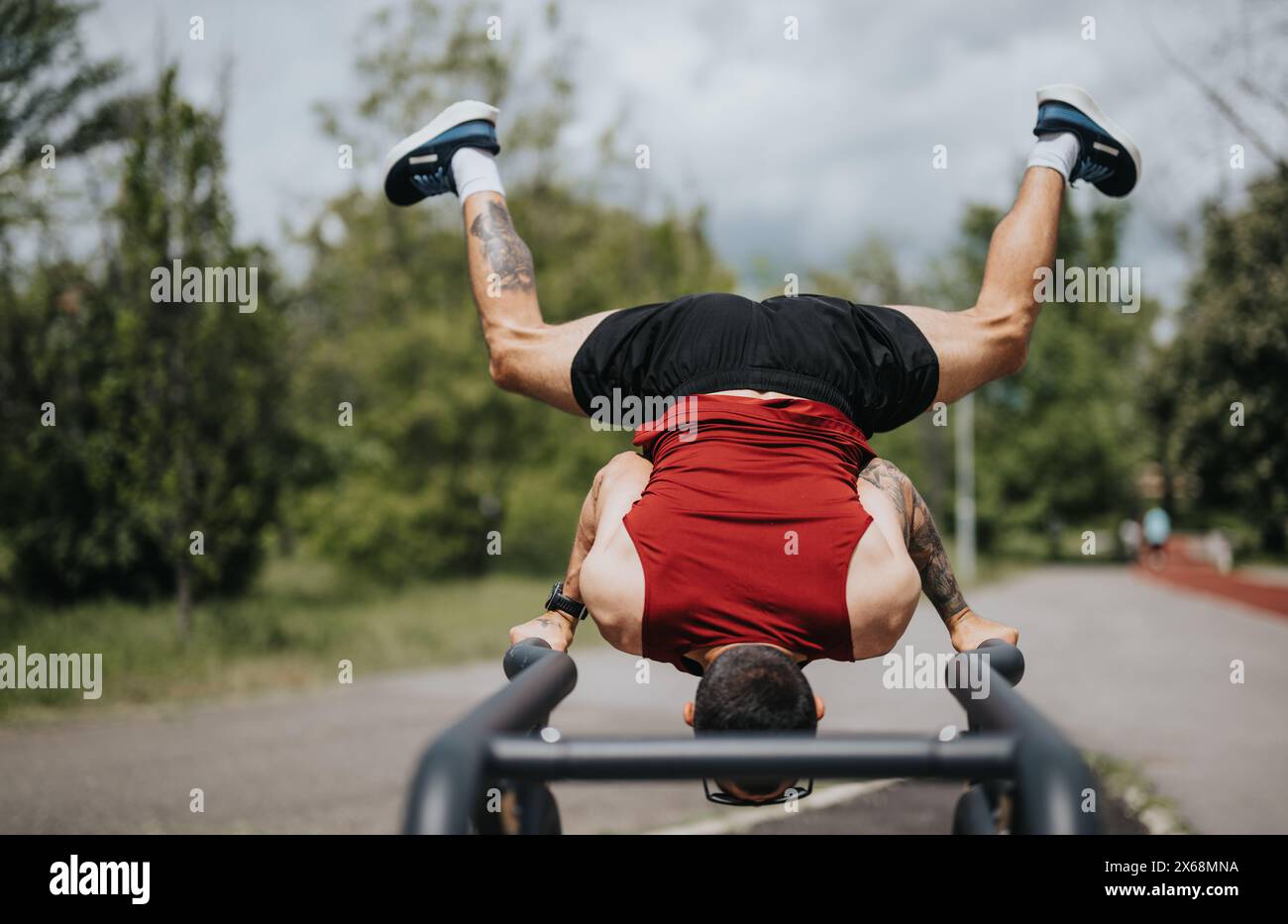 Athletic man performing advanced calisthenics workout in a park Stock ...
