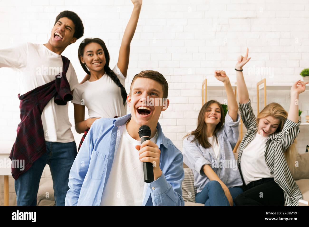 Group teenagers singing karaoke hi-res stock photography and images - Alamy