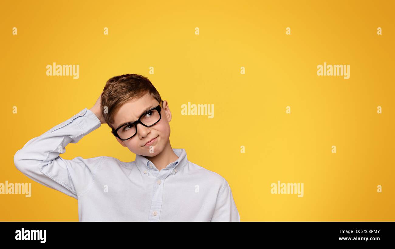 Doubtful teenage boy in glasses scratching his head Stock Photo - Alamy