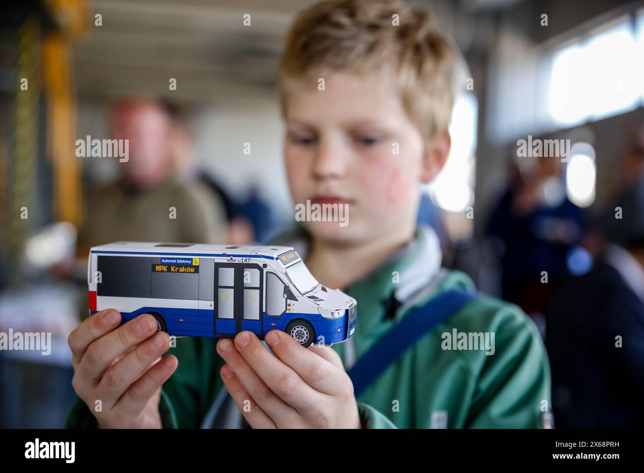 Krakow, Poland. 13th May, 2024. A boy holds a model of public bus as ...