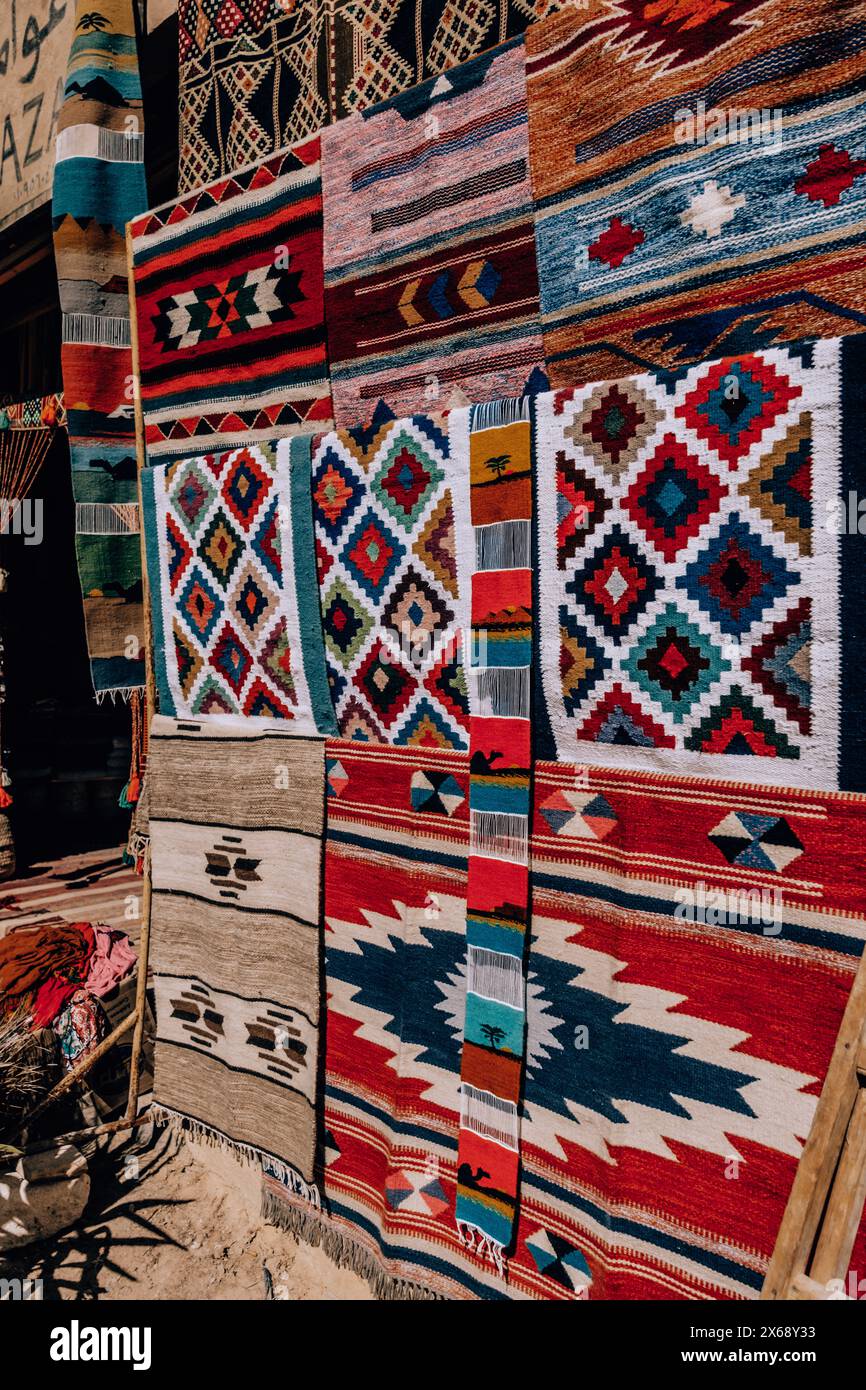 Colorful display of traditional woven rugs at a market in Siwa Oasis ...