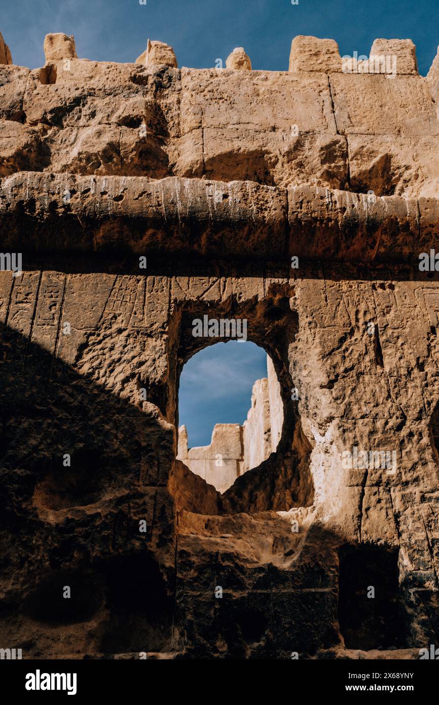 View through an ancient carved window in the stone ruins of the Oracle ...