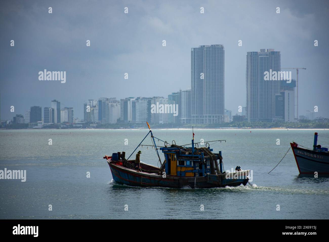 Fishing boat with modern Da Nang behind Stock Photo - Alamy