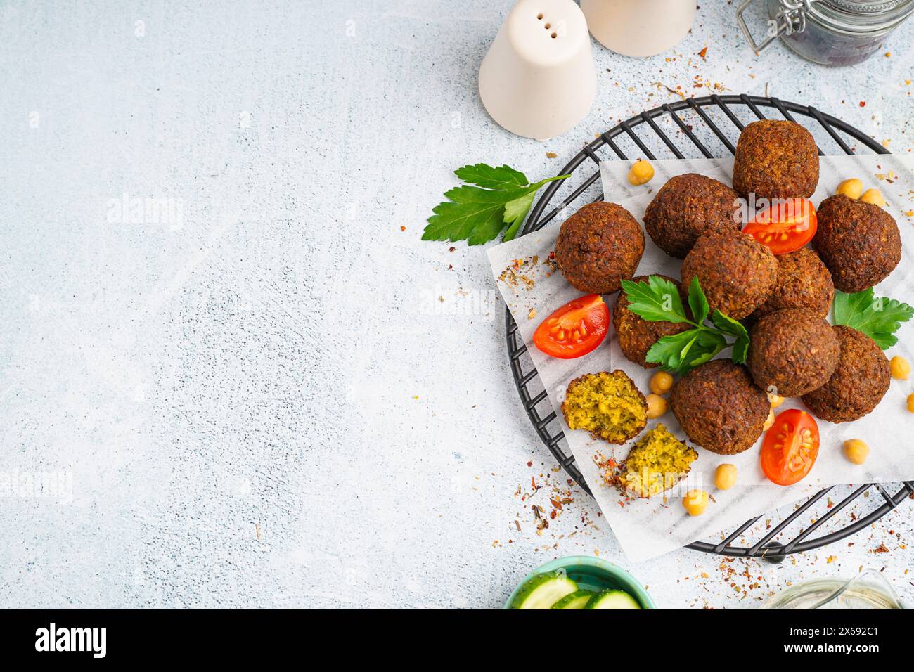 Stand with delicious falafel balls, chickpea and tomato on light ...