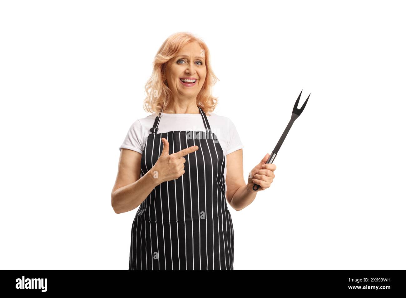 Woman wearing an apron and pointing at a big fork isolated on white ...