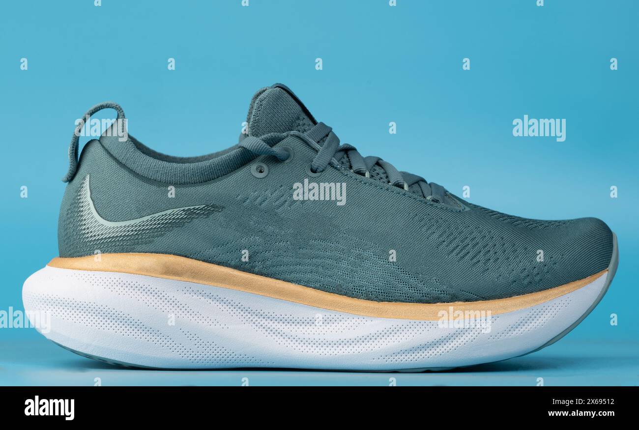 One green sport shoe side view on blue studio background Stock Photo ...