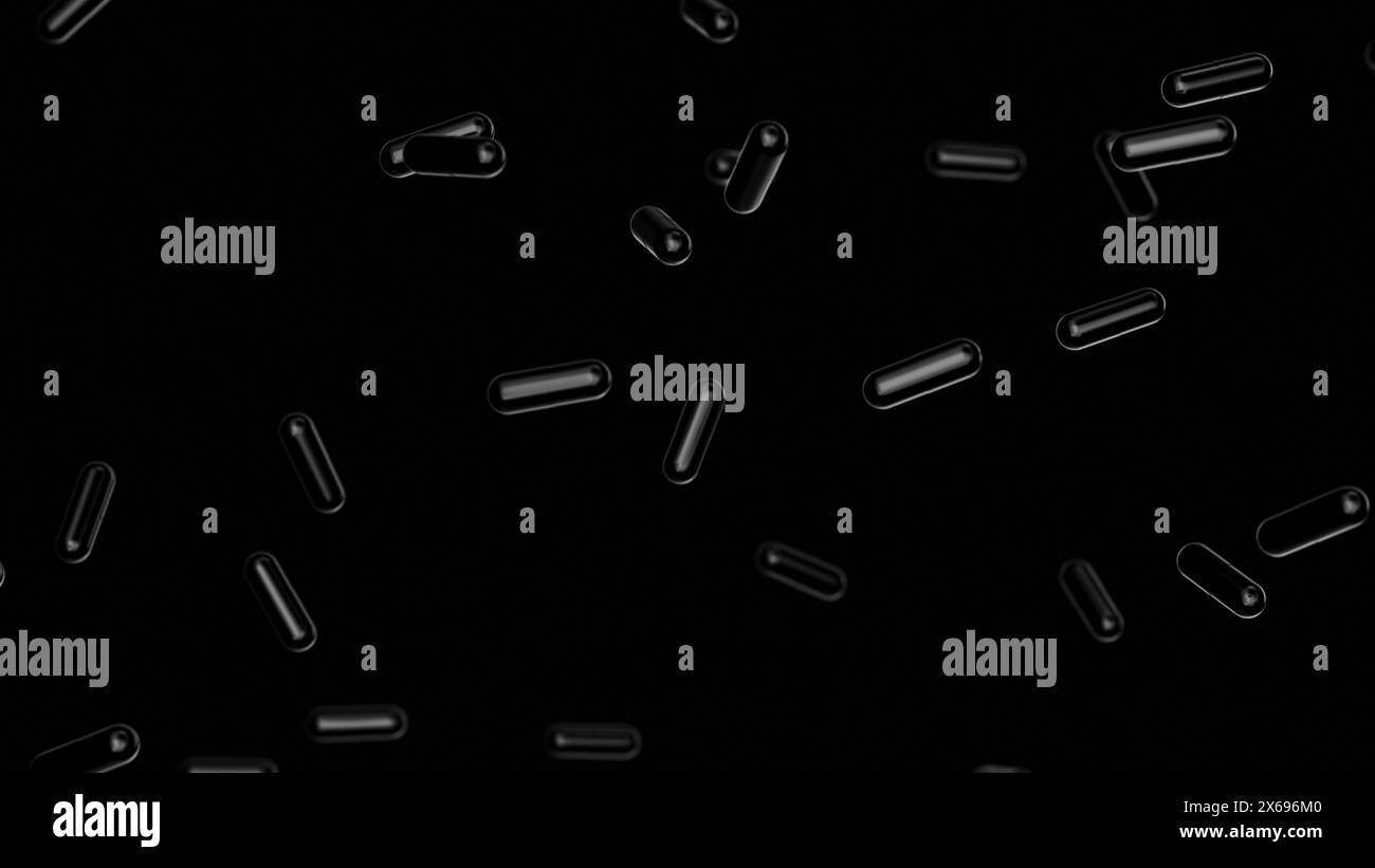 Black capsules fall against black backdrop. Drugs, pills, tablets ...