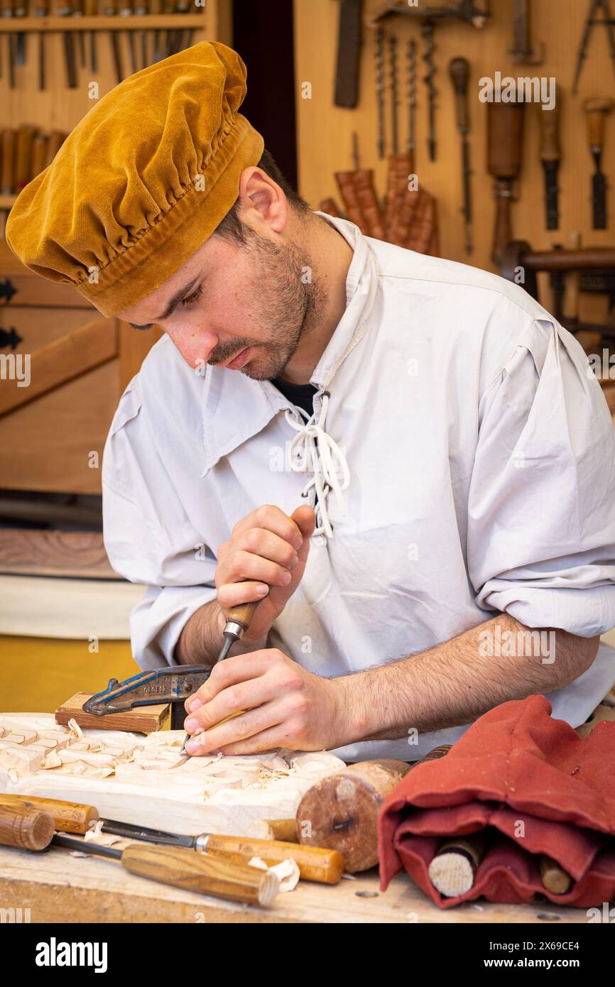 A wood craftsman, making a sample of his work, during the medieval ...