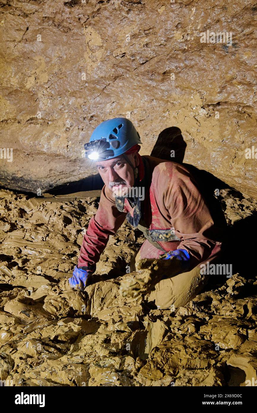 Cave explorers in the mud Stock Photo - Alamy