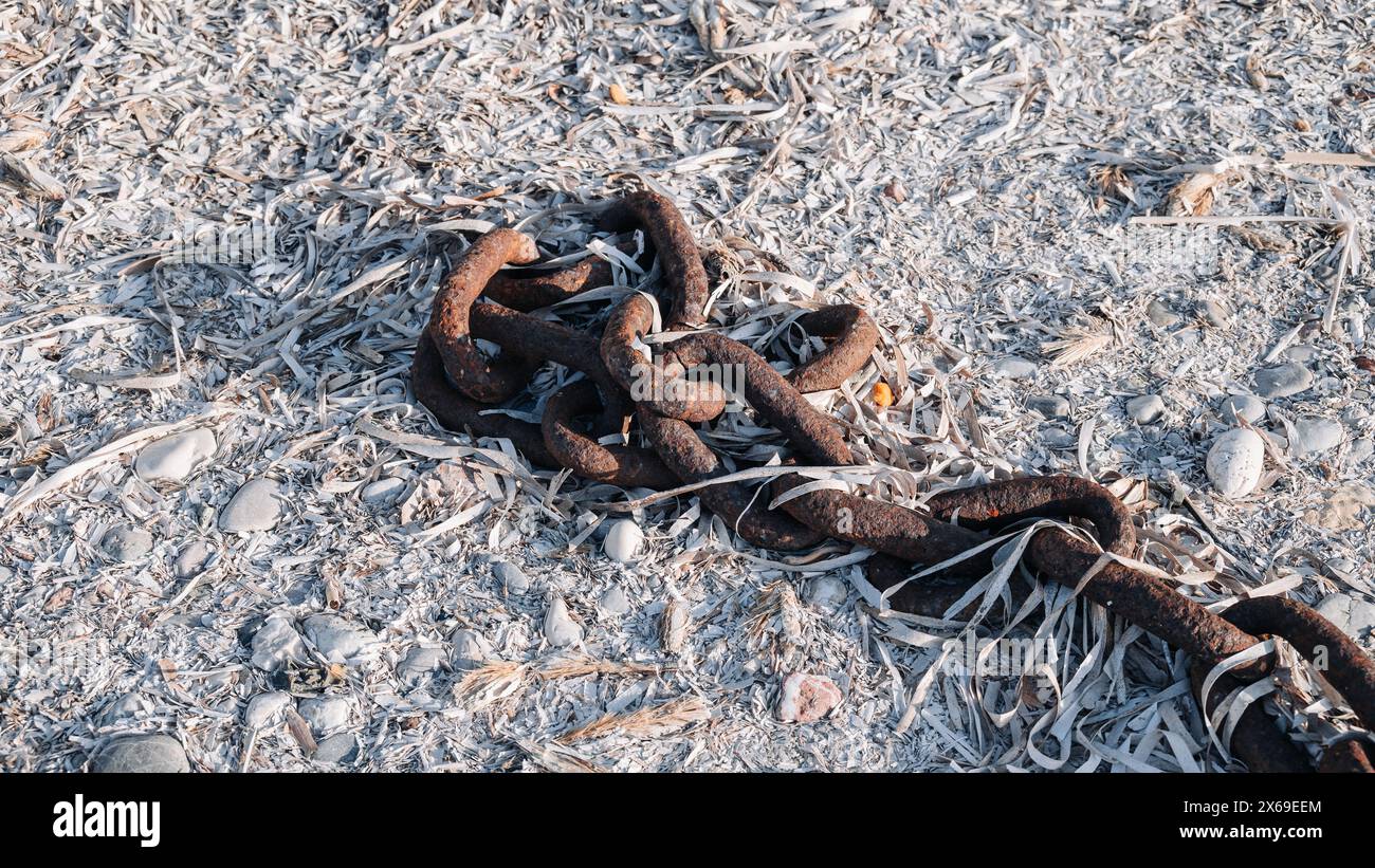 Big rusty skimpy chain on the rocks Stock Photo - Alamy